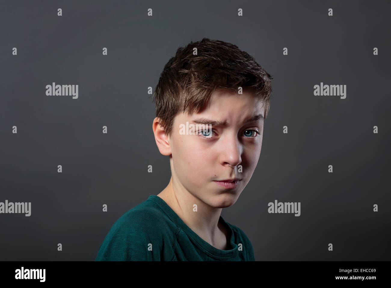 portrait of a doubting teenage boy with gray background for fast ...