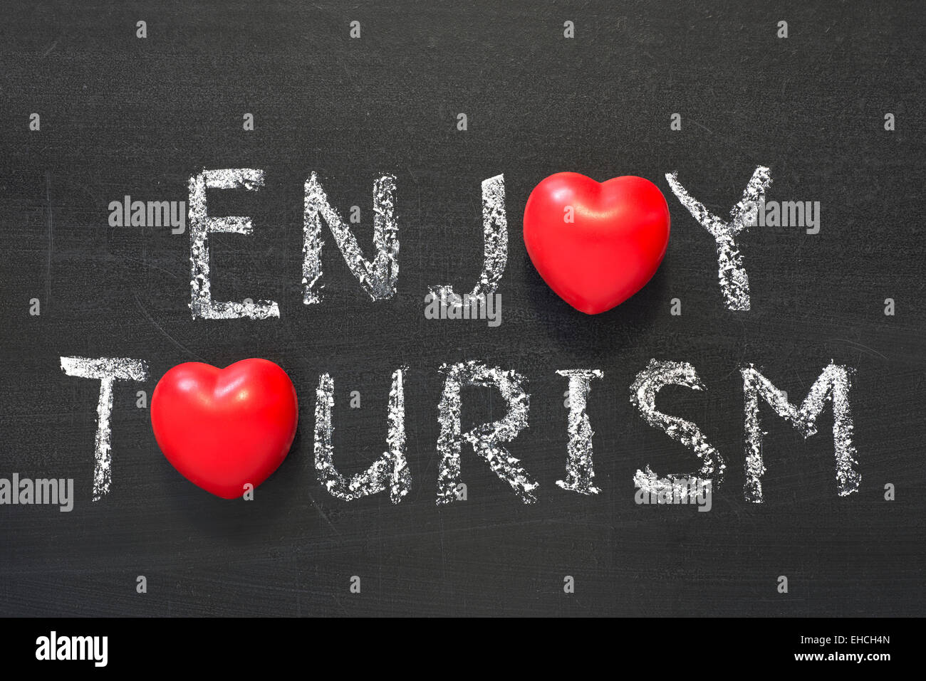 enjoy tourism phrase handwritten on school blackboard Stock Photo - Alamy