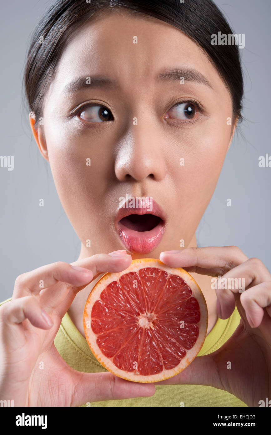 Young woman eating grapefruit Stock Photo - Alamy