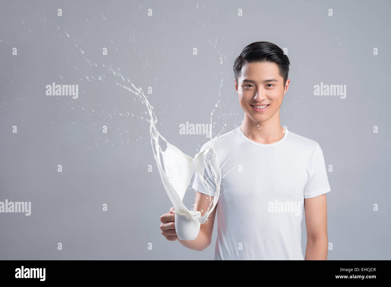 Young man with splashing milk Stock Photo - Alamy