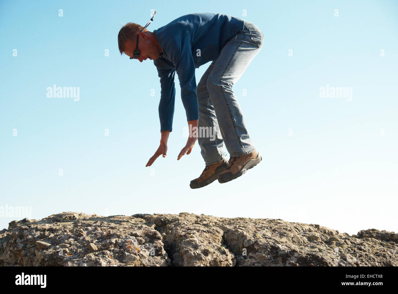 Falling down man from the rock with blue background Stock Photo - Alamy