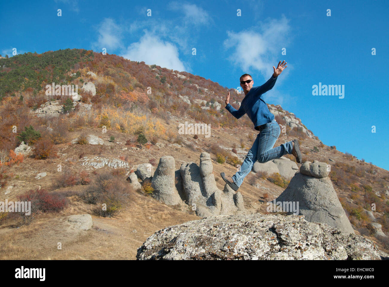 Man jumping on the rocks with landscape background Stock Photo - Alamy
