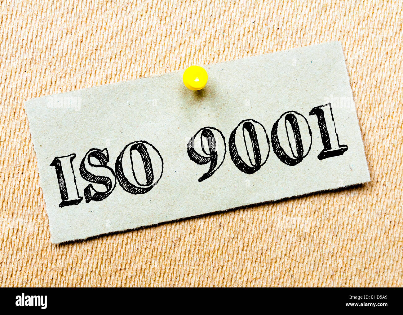 Recycled paper note pinned on cork board. ISO 9001 Message. Concept ...