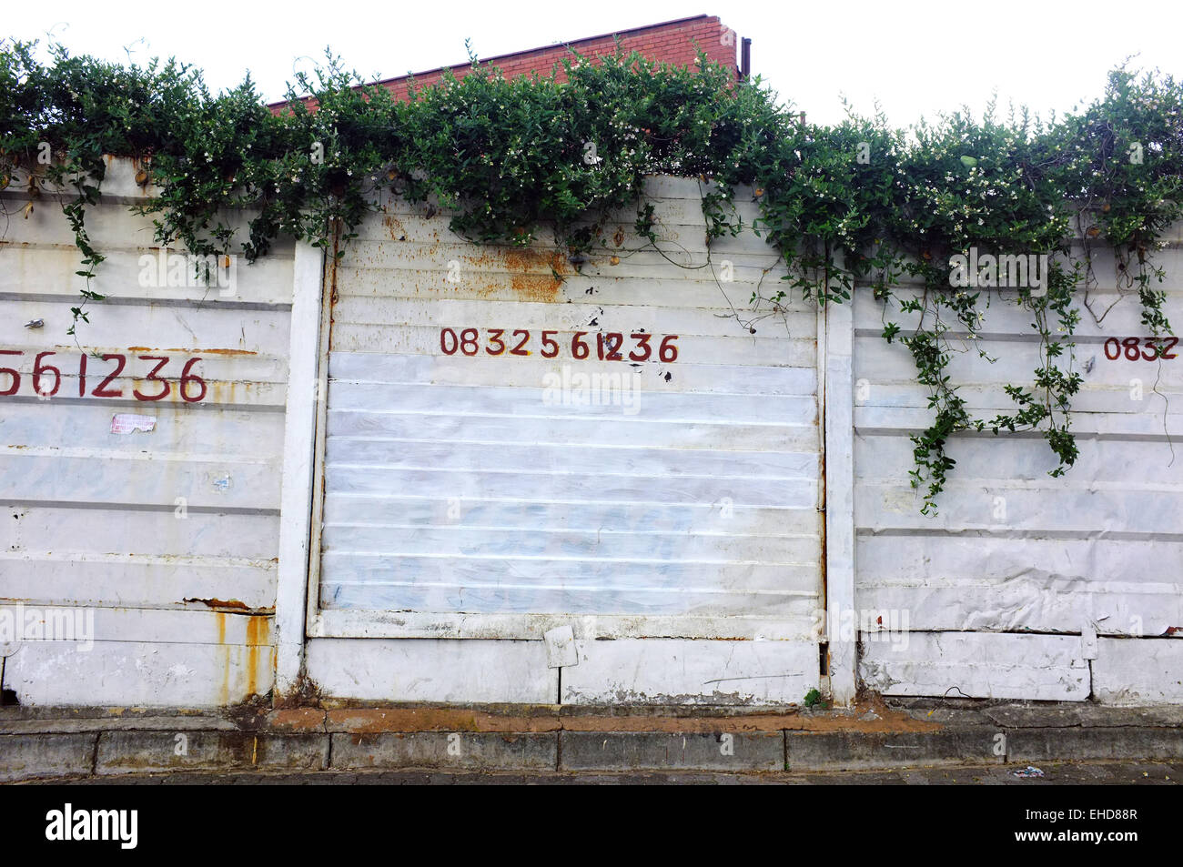 Telephone numbers painted onto a wall along a road in Johannesburg ...