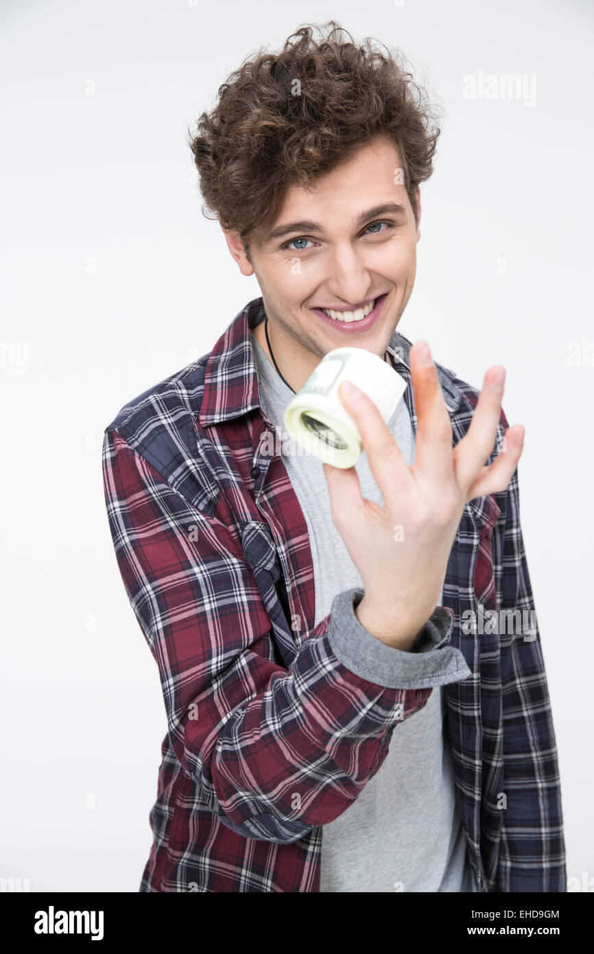 Smiling young man holding money over gray background Stock Photo - Alamy