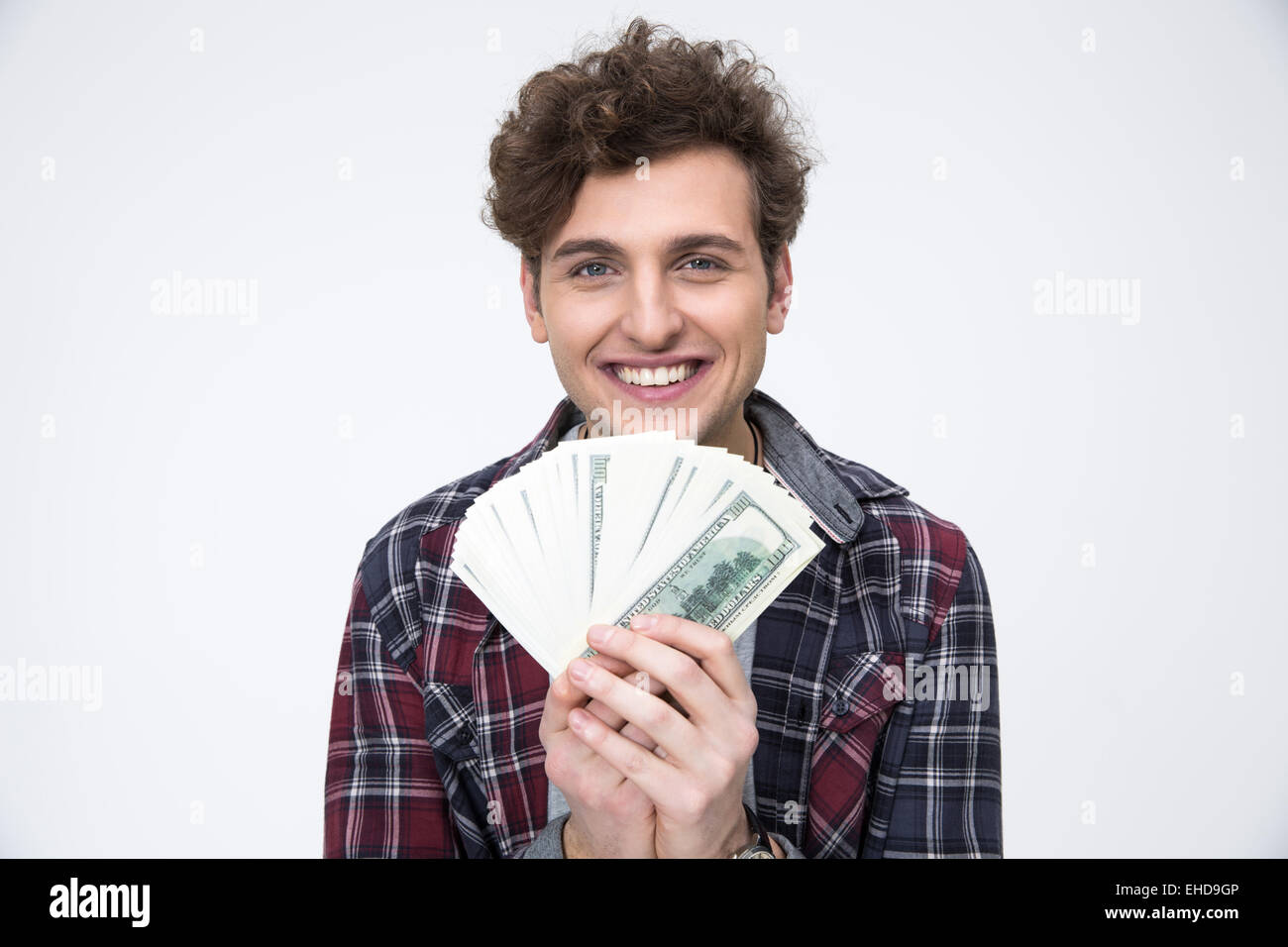 Smiling young man holding money over gray background Stock Photo - Alamy