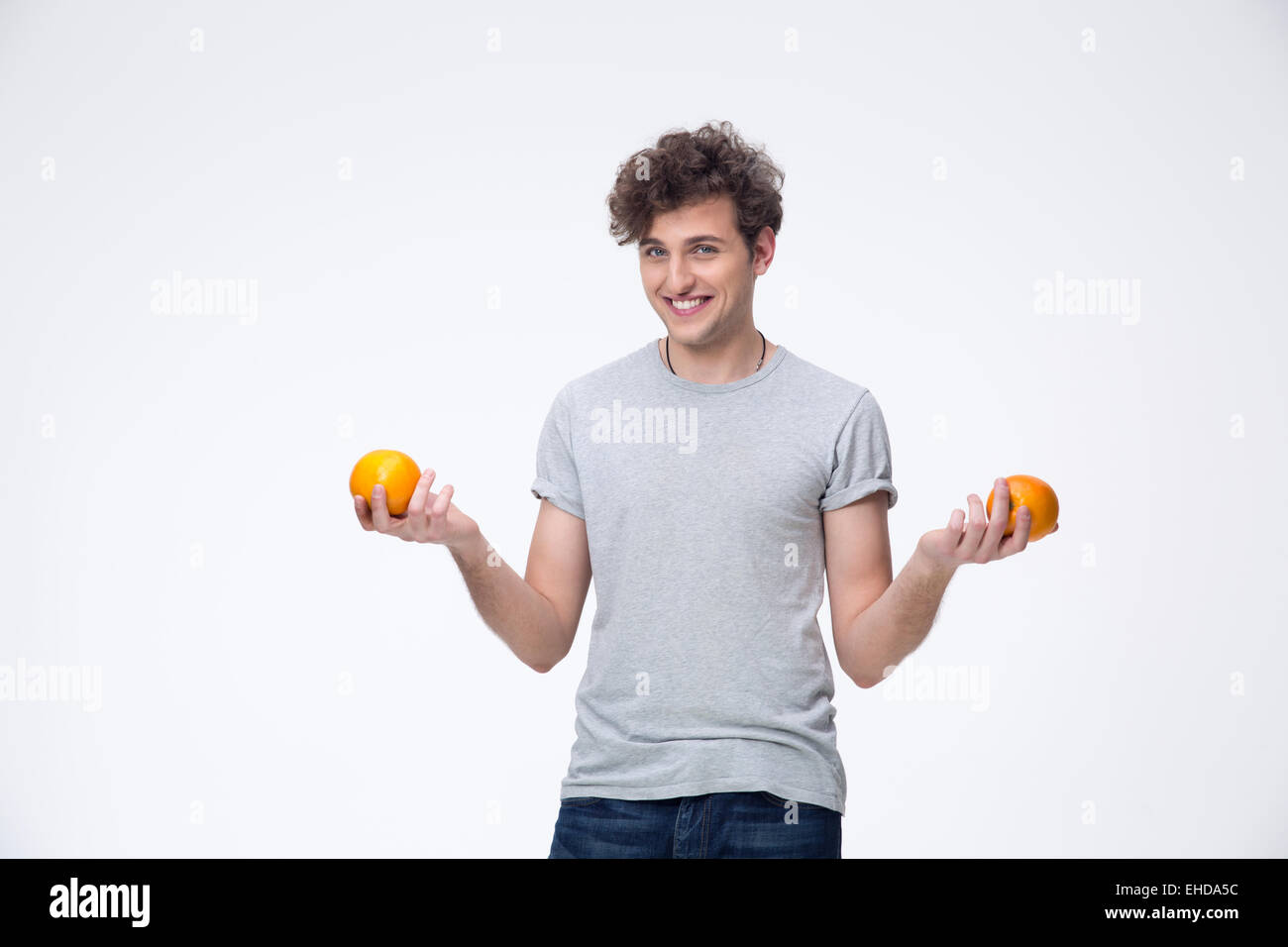 Portrait of a happy young man holding orange Stock Photo - Alamy