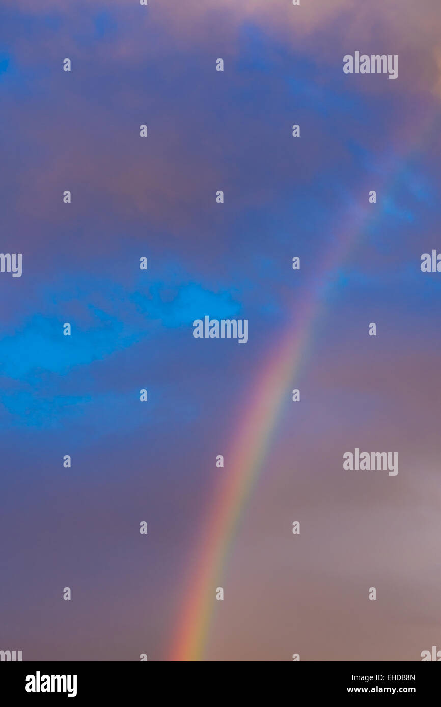 Rainbow bursting through clouds at dusk Stock Photo - Alamy