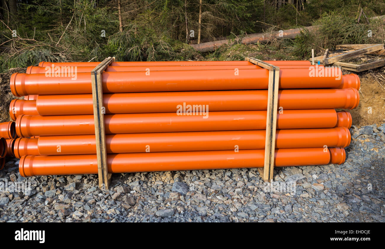 Orange pipes stored on a construction site Stock Photo - Alamy