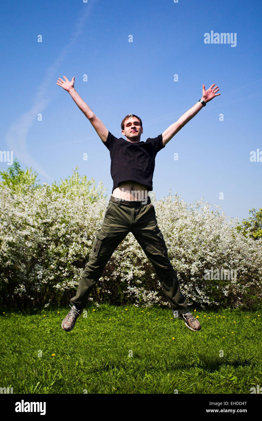 Active jumping man on green grass Stock Photo - Alamy