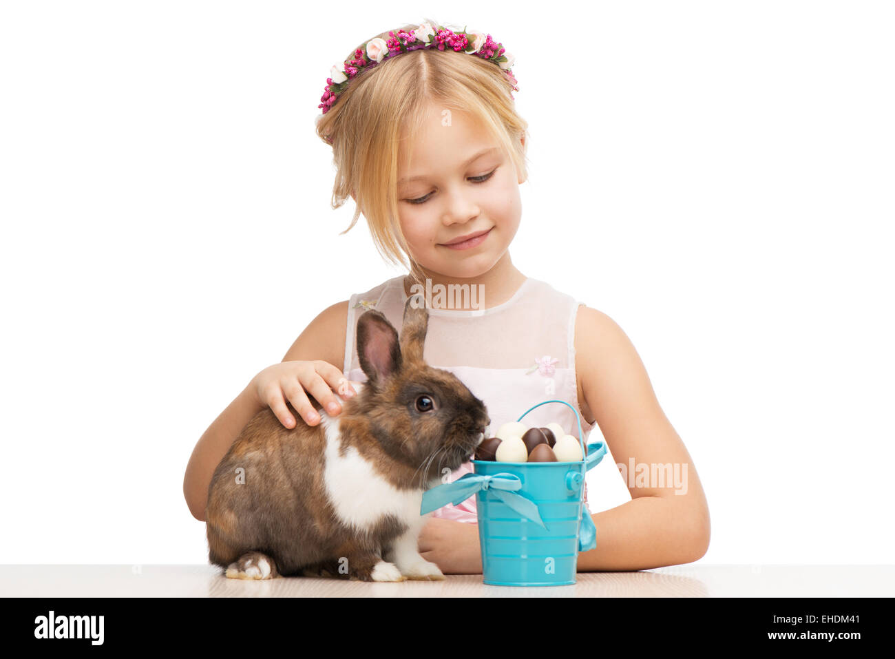 Smiling girl feeding bunny with chocolate eggs Stock Photo - Alamy