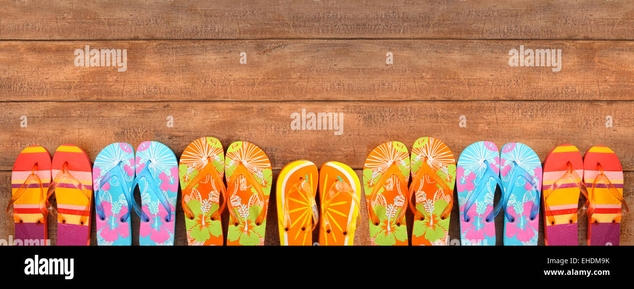 Brightly colored flip-flops on wood Stock Photo - Alamy