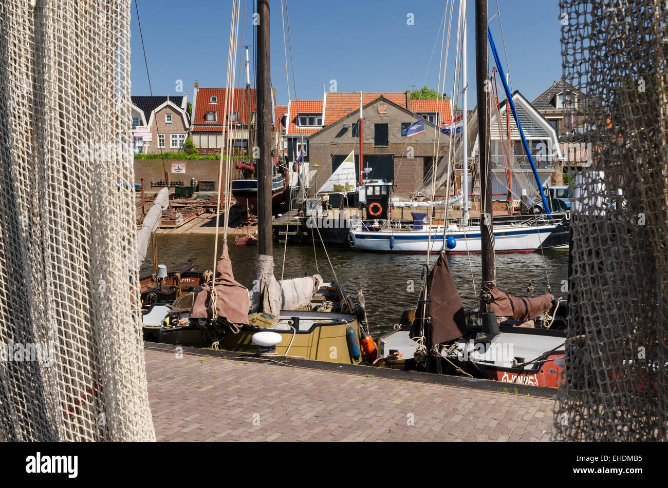 Old harbor of Urk with some old vessels and a sailing ship in Flevoland ...