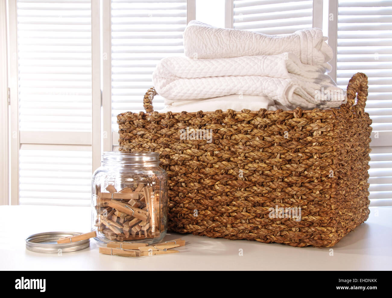 Laundry basket with linens on table Stock Photo - Alamy
