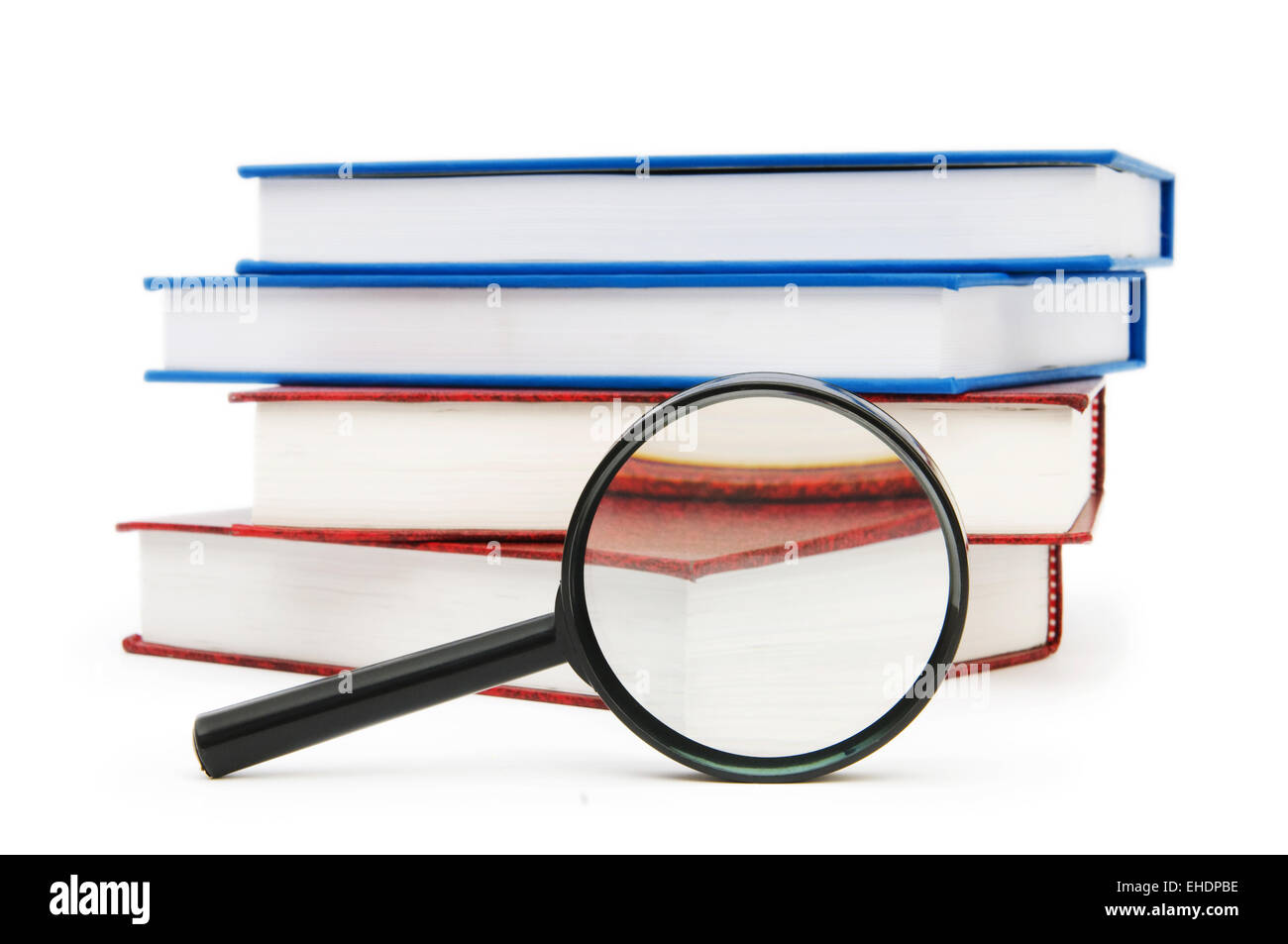 Magnifying glass over the stack of books Stock Photo - Alamy