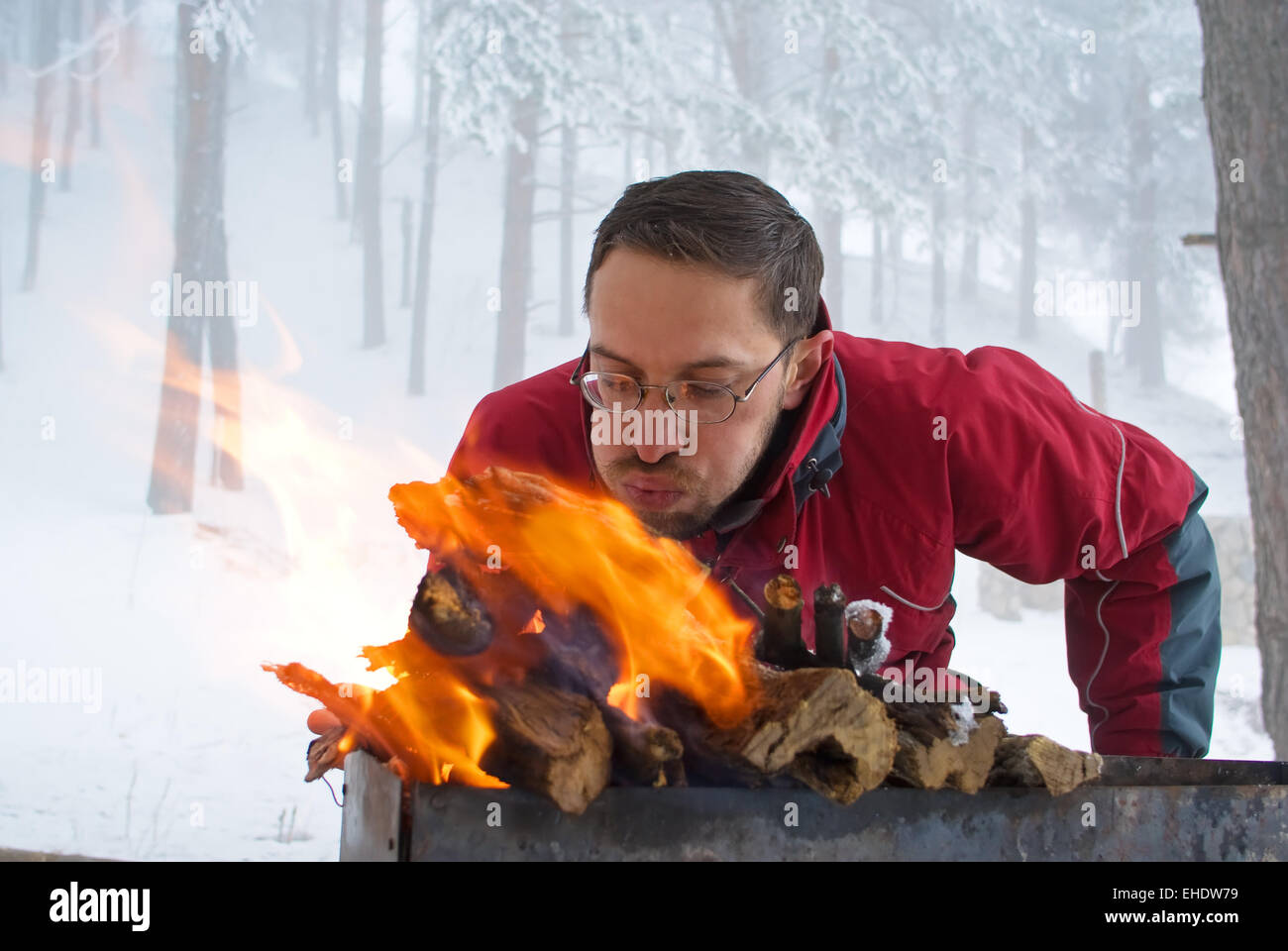 Man fanning fire in grill Stock Photo - Alamy