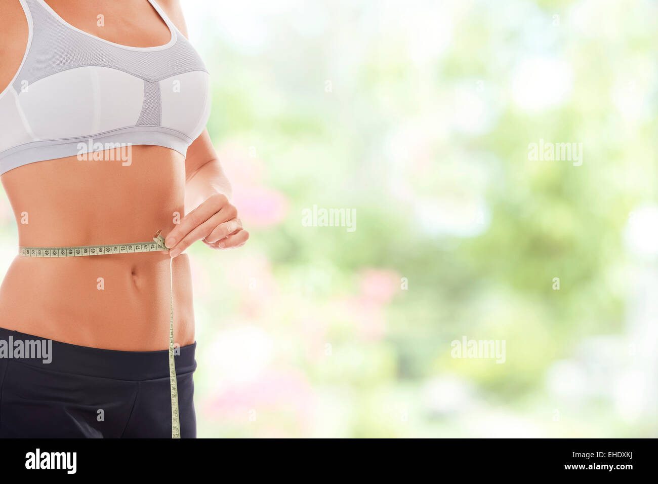 Close up view of young beautiful woman measuring her waist Stock Photo ...