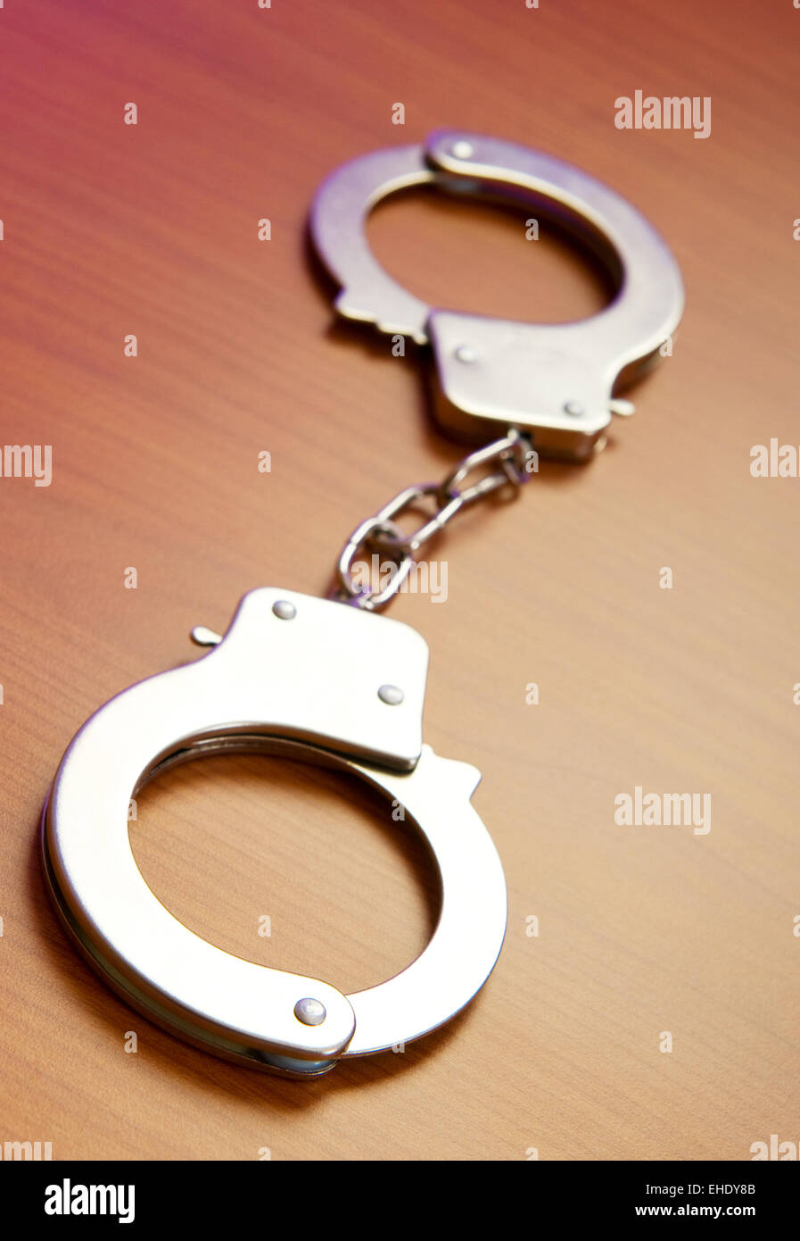 Metal handcuffs on the wooden background Stock Photo - Alamy
