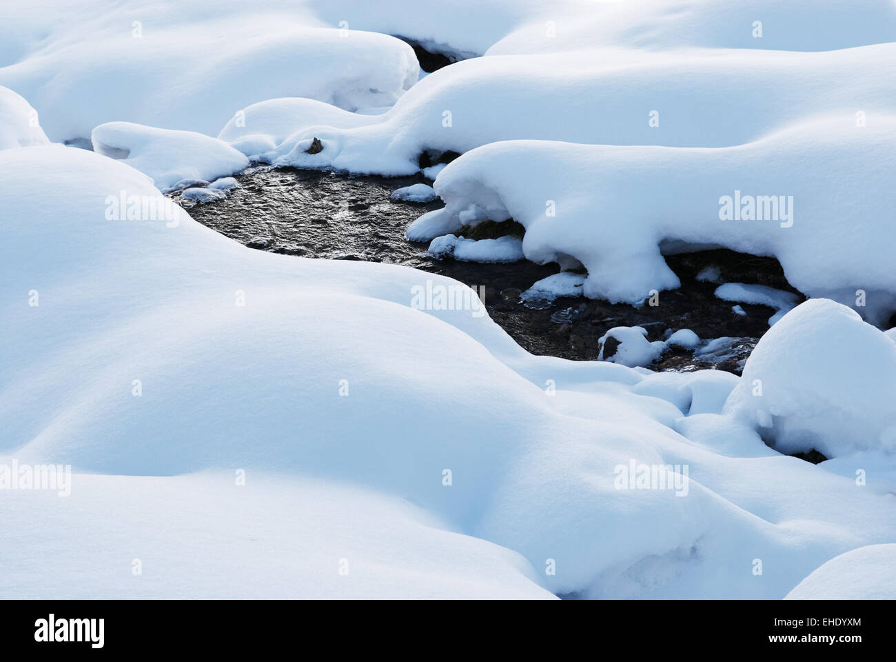 Snow and small creek Stock Photo - Alamy