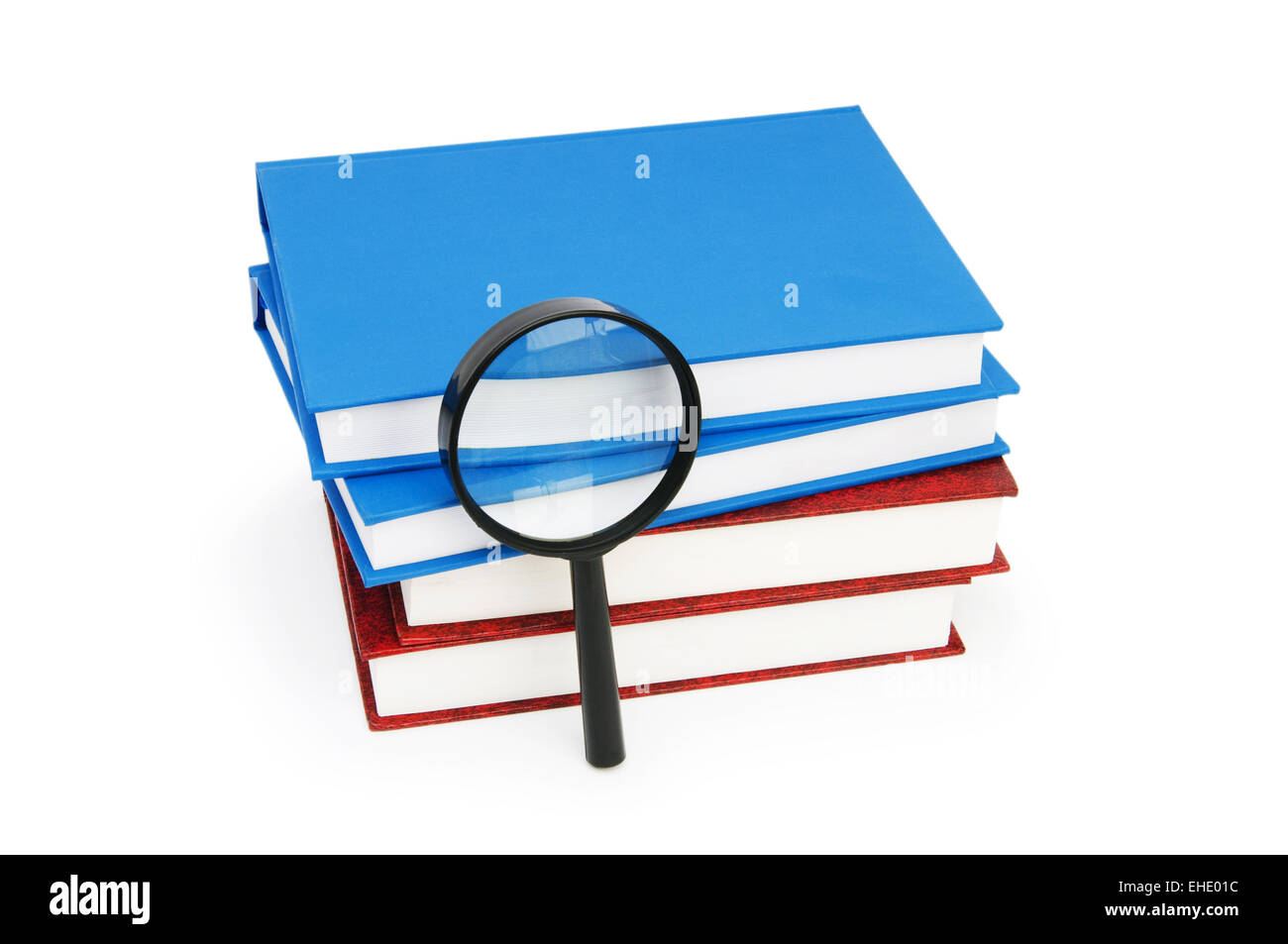 Magnifying glass over the stack of books Stock Photo - Alamy