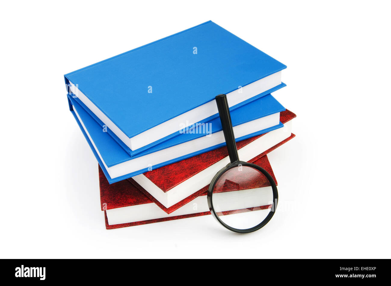 Magnifying glass over the stack of books Stock Photo - Alamy