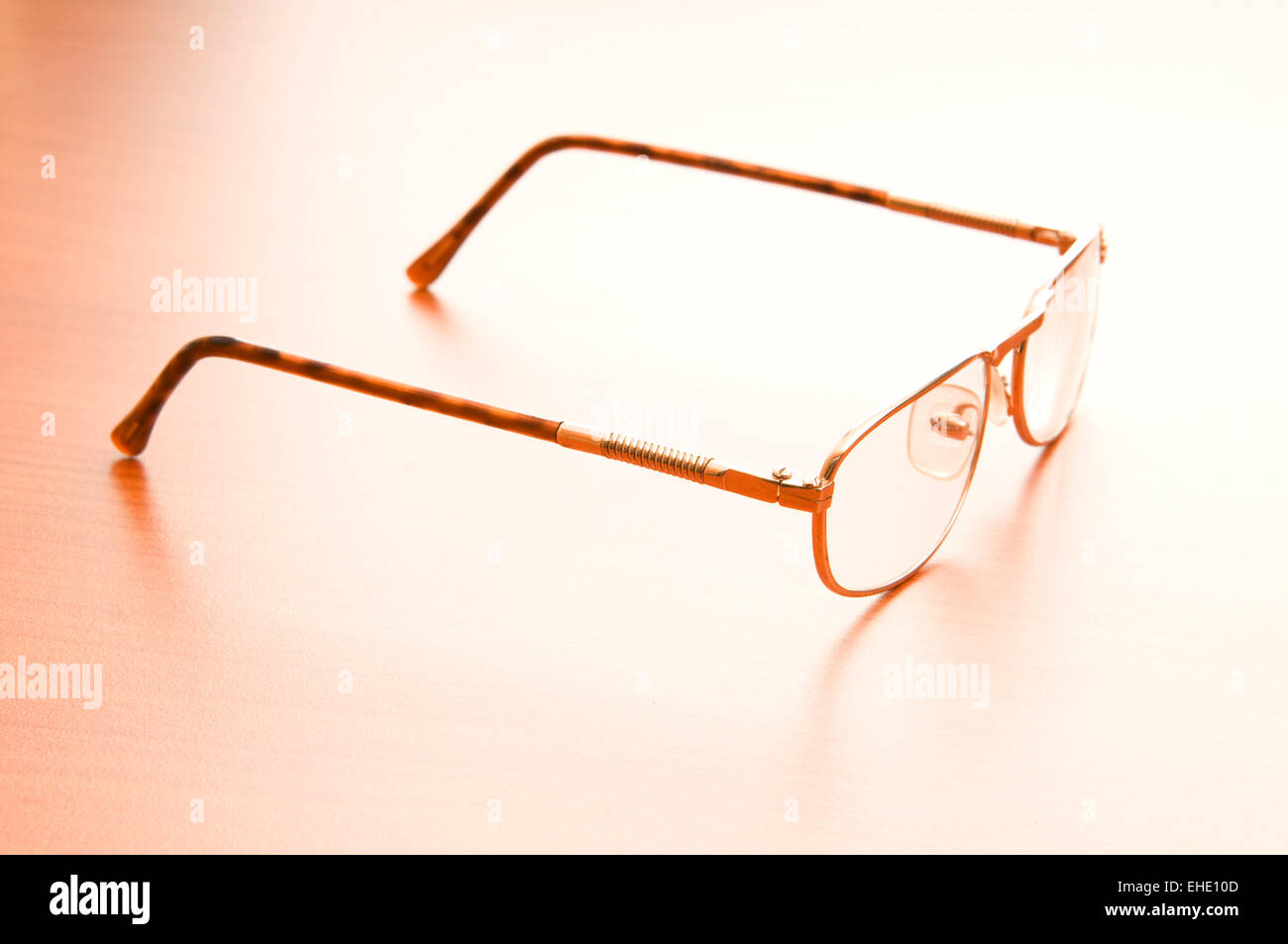 Reading glasses on the wooden table Stock Photo - Alamy