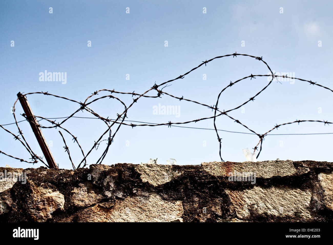 Stone wall with barbed wire Stock Photo - Alamy