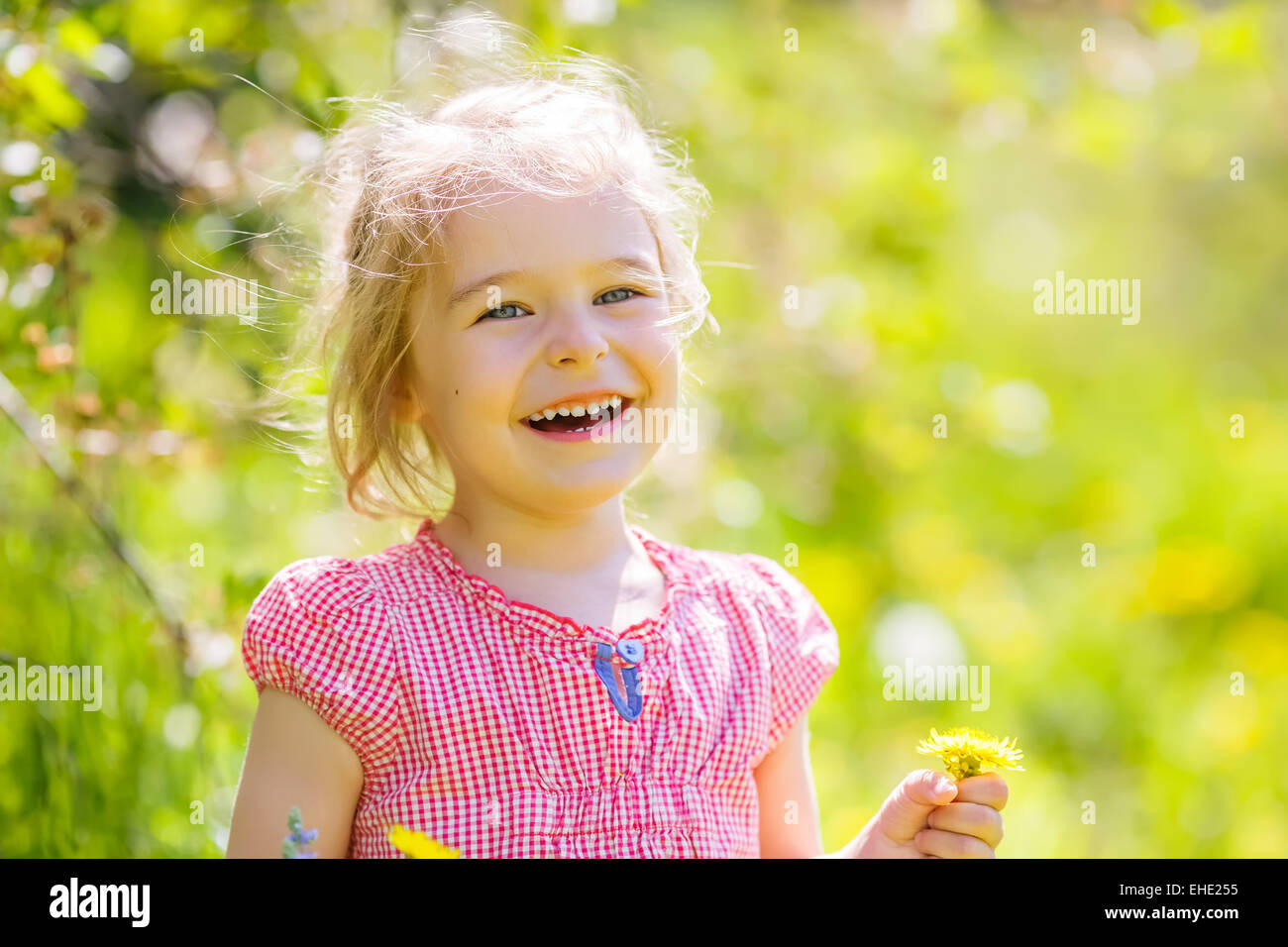 Happy little girl in spring sunny park Stock Photo - Alamy