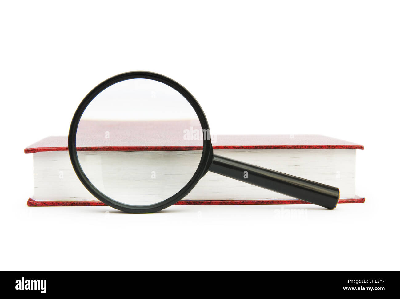 Magnifying glass over the stack of books Stock Photo - Alamy