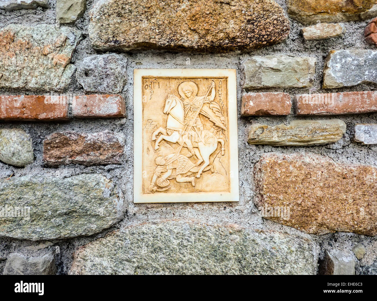 Ancient Greek Saint image made of marble on the stone wall. Background ...