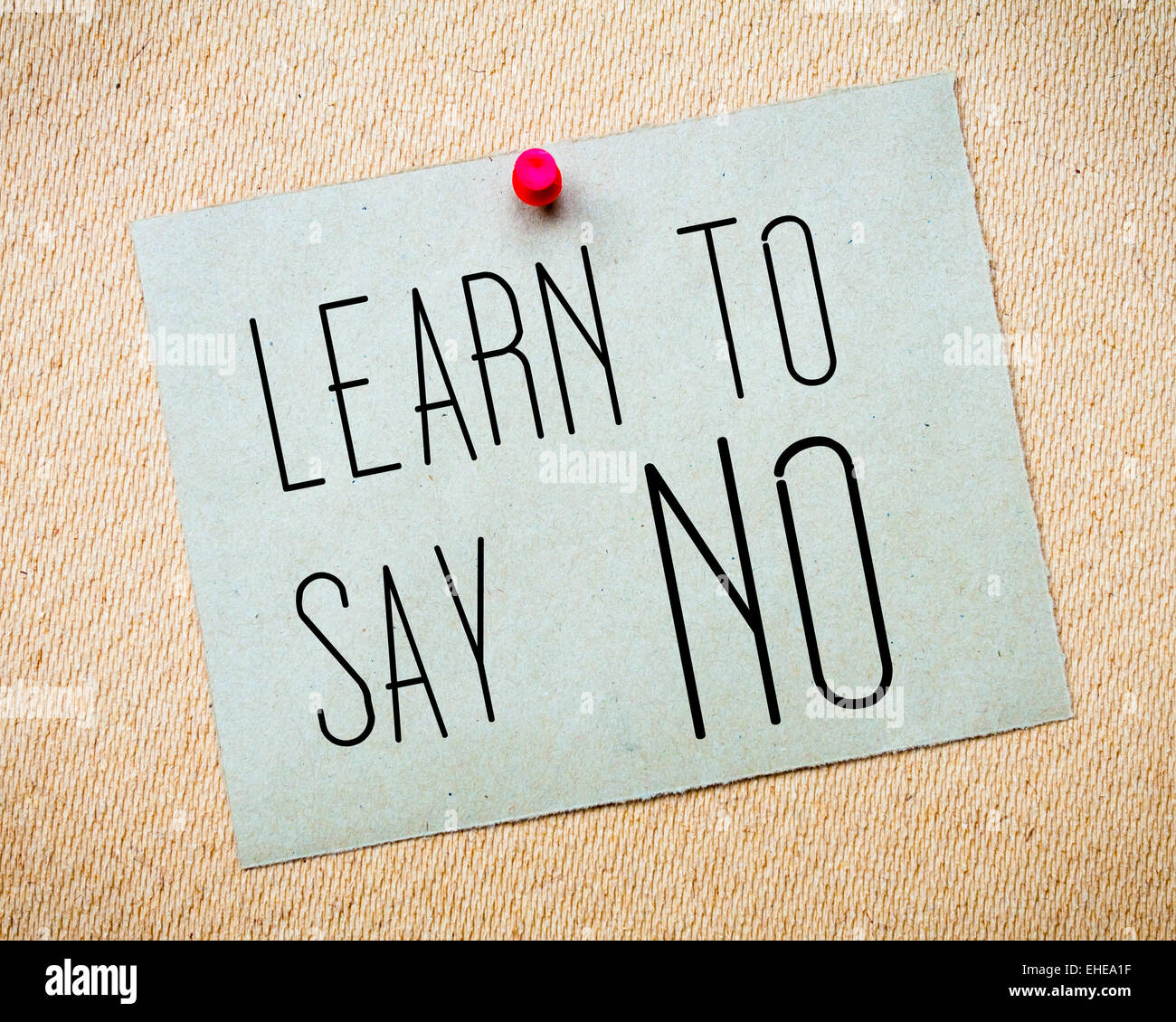 Recycled paper note pinned on cork board. Learn to say NO Message ...