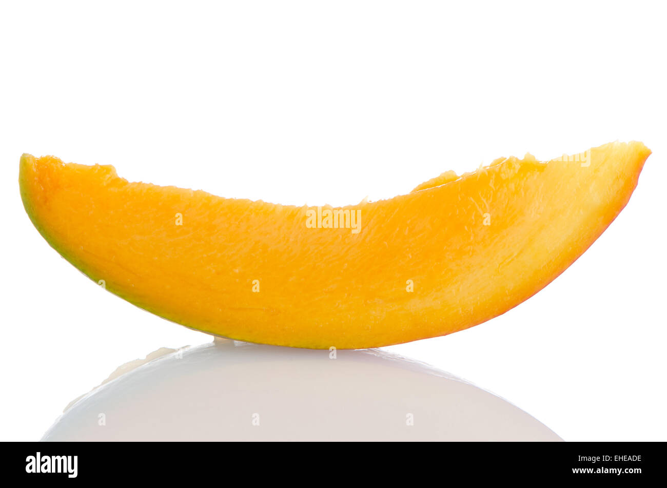 Mango fruit slice on white reflective background Stock Photo - Alamy