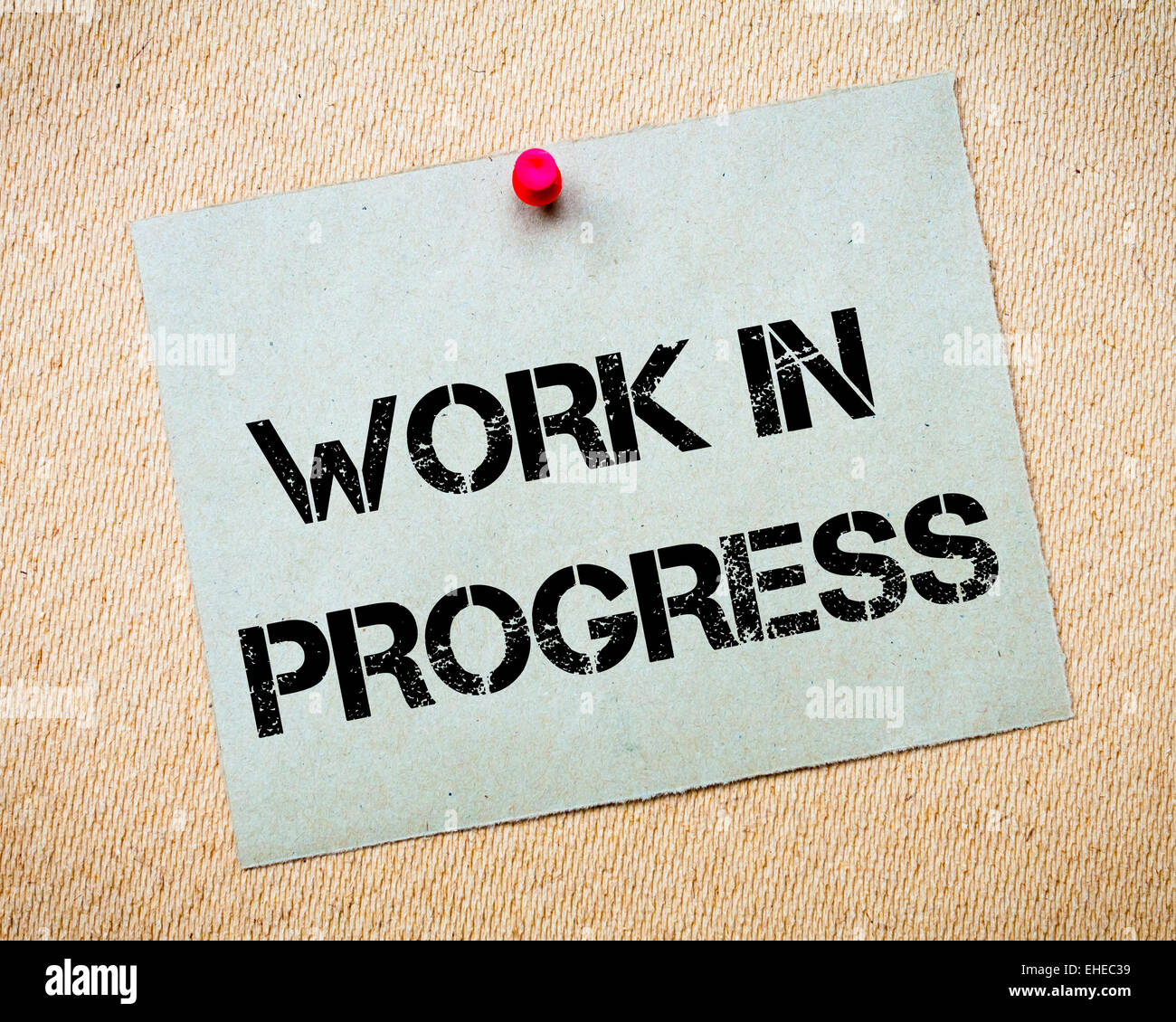 Recycled paper note pinned on cork board. Work in Progress Message ...