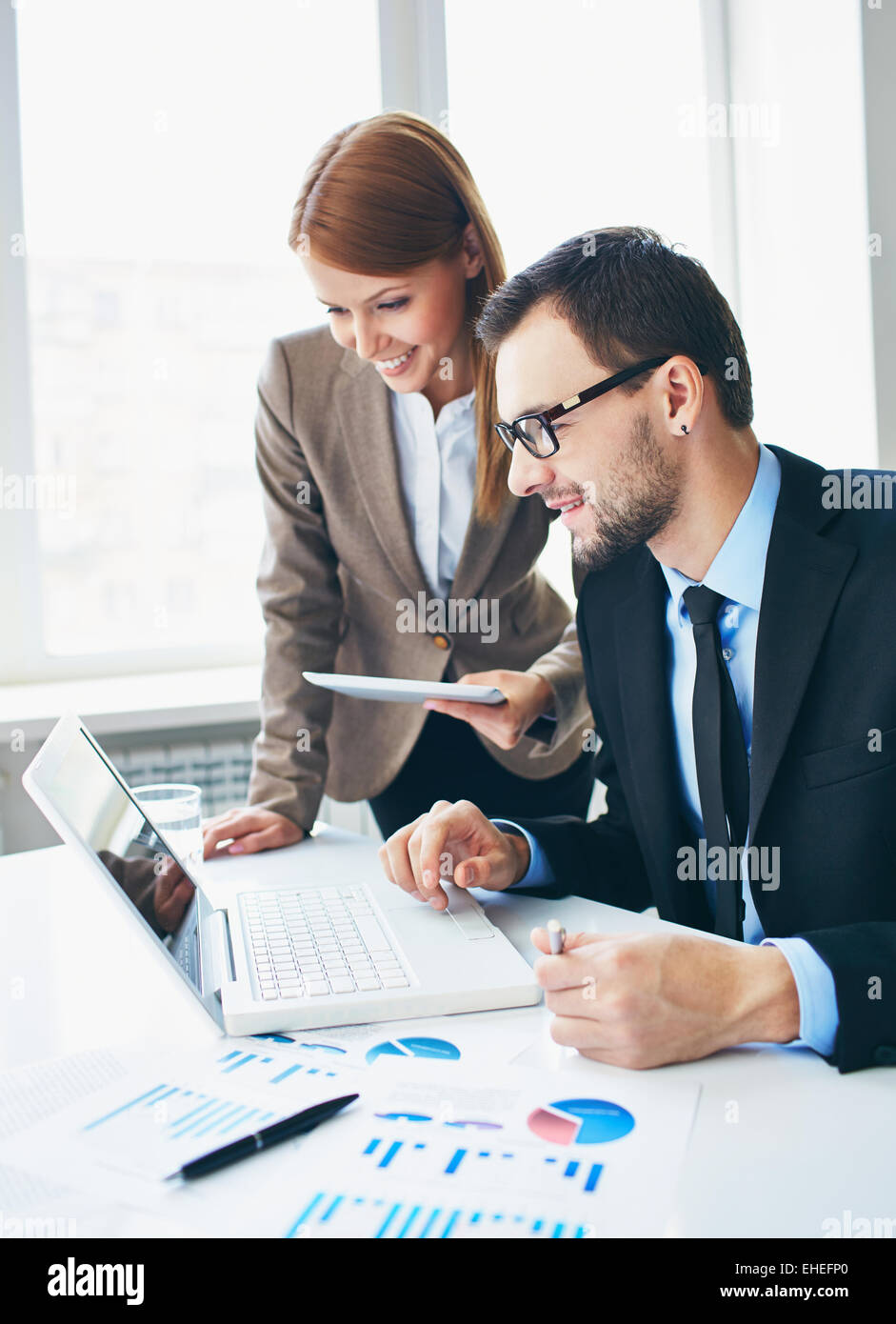 Two office workers watching something on laptop Stock Photo - Alamy