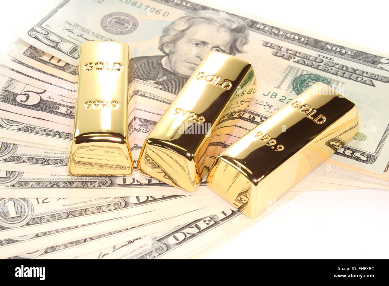 three gold bars on dollar bills Stock Photo - Alamy