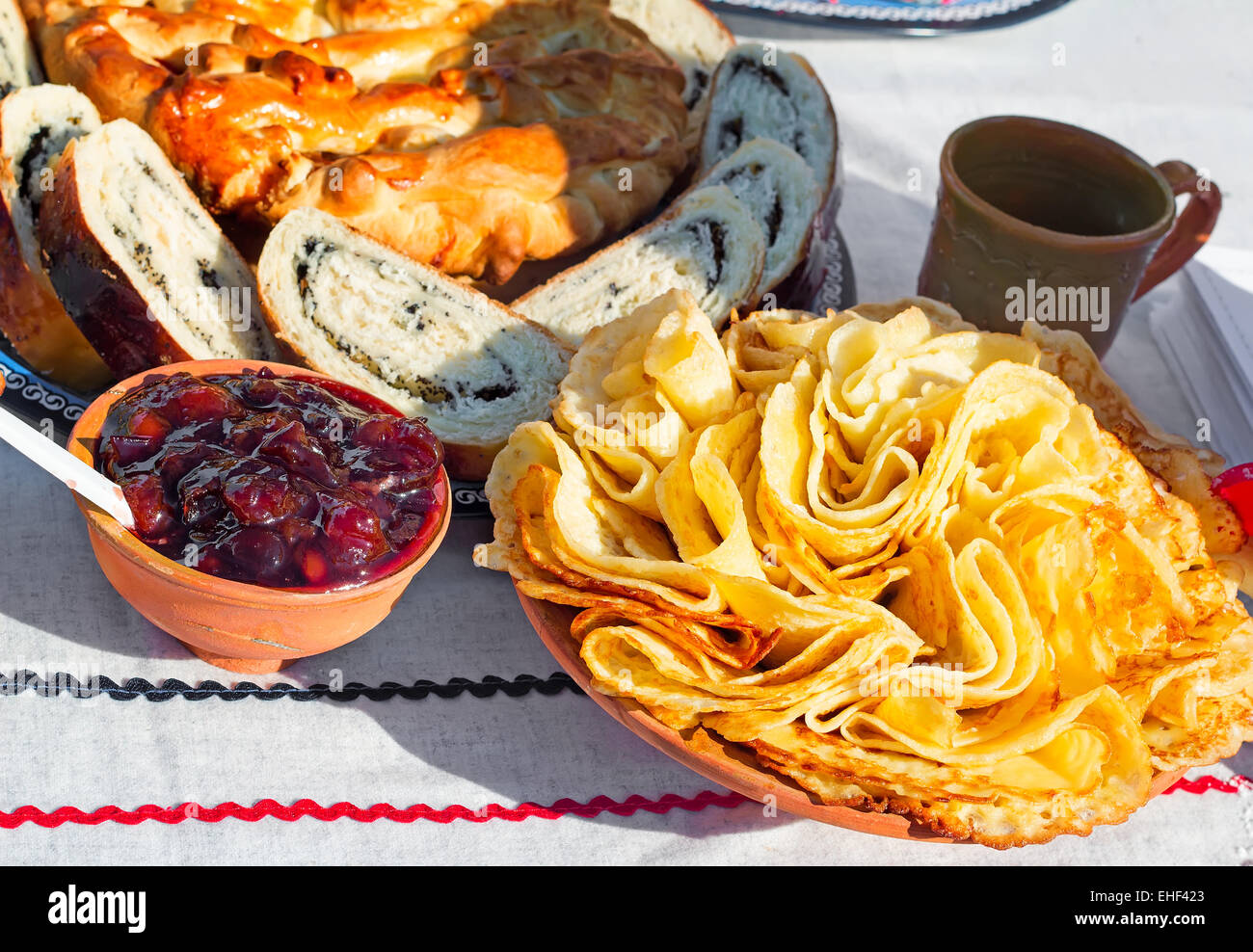 Delicious fried pancakes and rolls are covered with a white embroidered ...