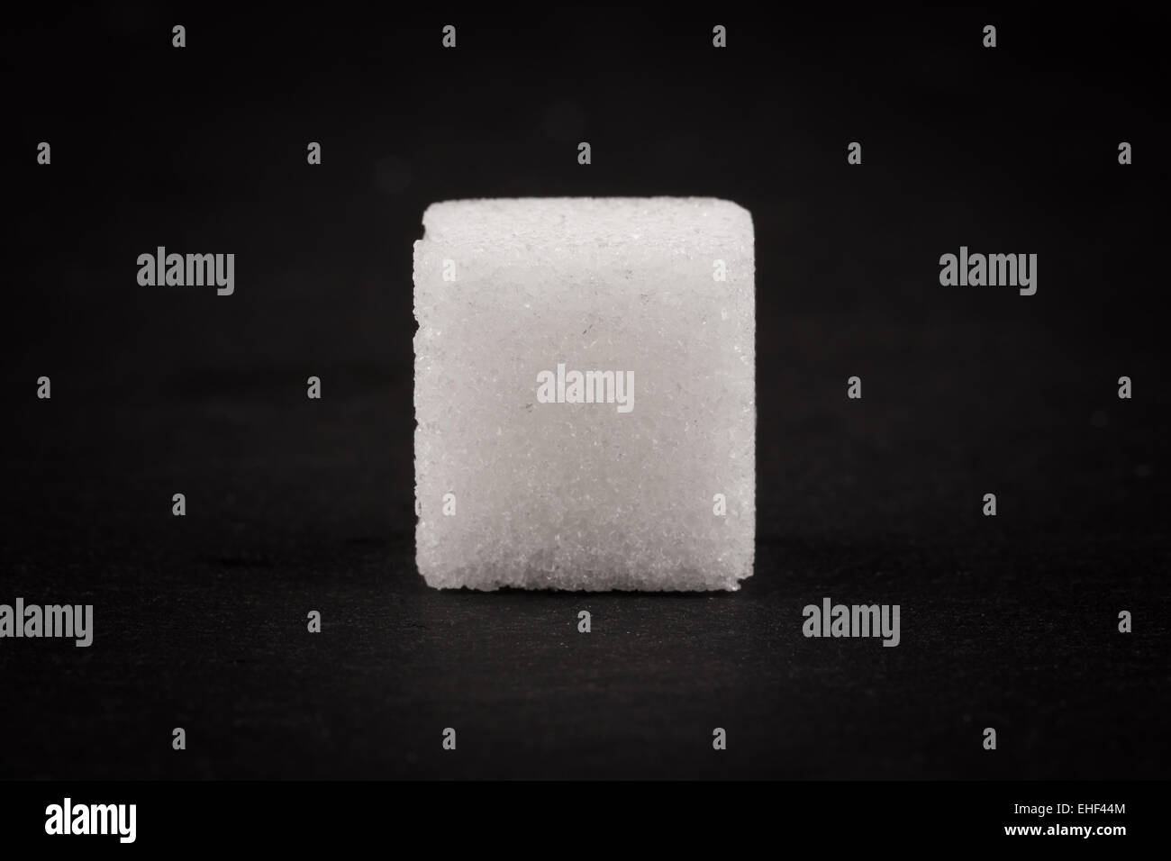 White refined sugar on dark stone background Stock Photo - Alamy