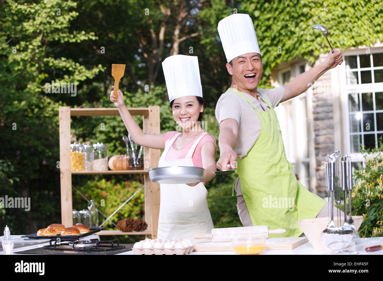The young couple with a chef's in the kitchen Stock Photo - Alamy