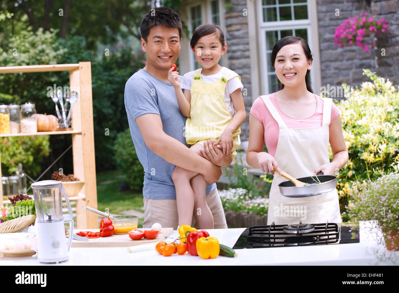 Father held his daughter watched her mother with the cooking Stock ...
