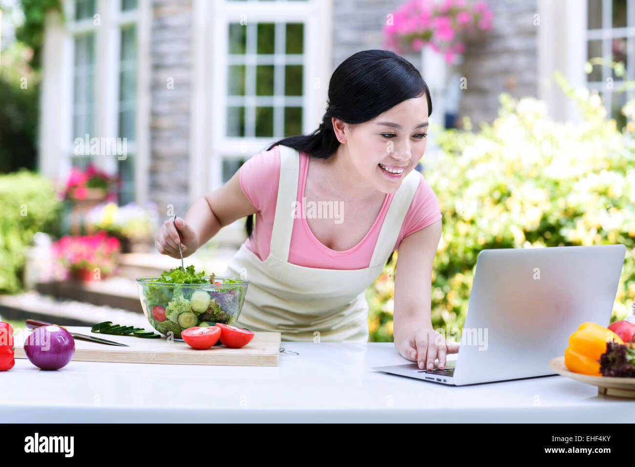 Oriental women in outdoor kitchen to use a computer Stock Photo - Alamy