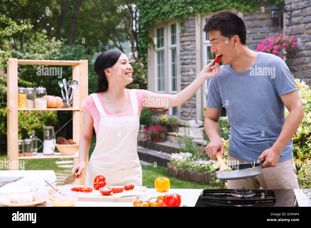 The young couple cook in the outdoor kitchen Stock Photo - Alamy