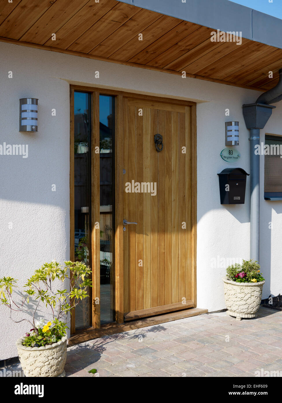 Pine front door with a pair of planters and matching wall lights in ...