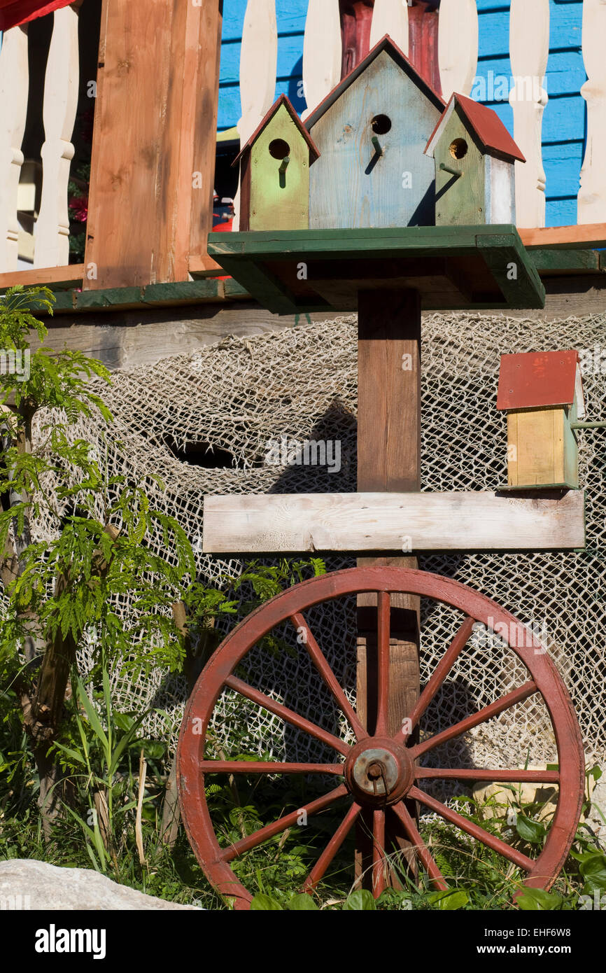 Wooden Colored bird houses on a wagon wheel Stock Photo - Alamy