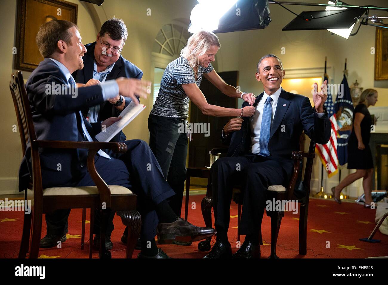 US President Barack Obama laughs as he is miked for an interview with ...
