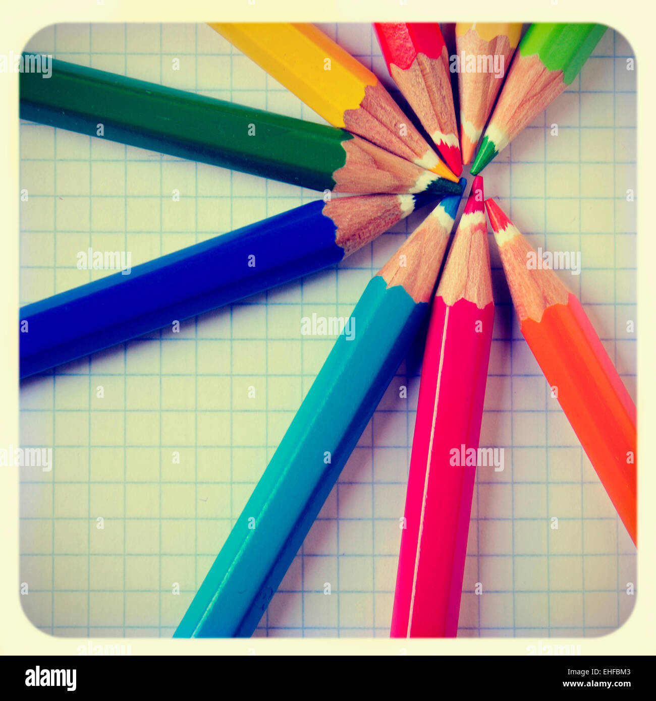 some pencil crayons of different colors on a notebook, with a frame and ...