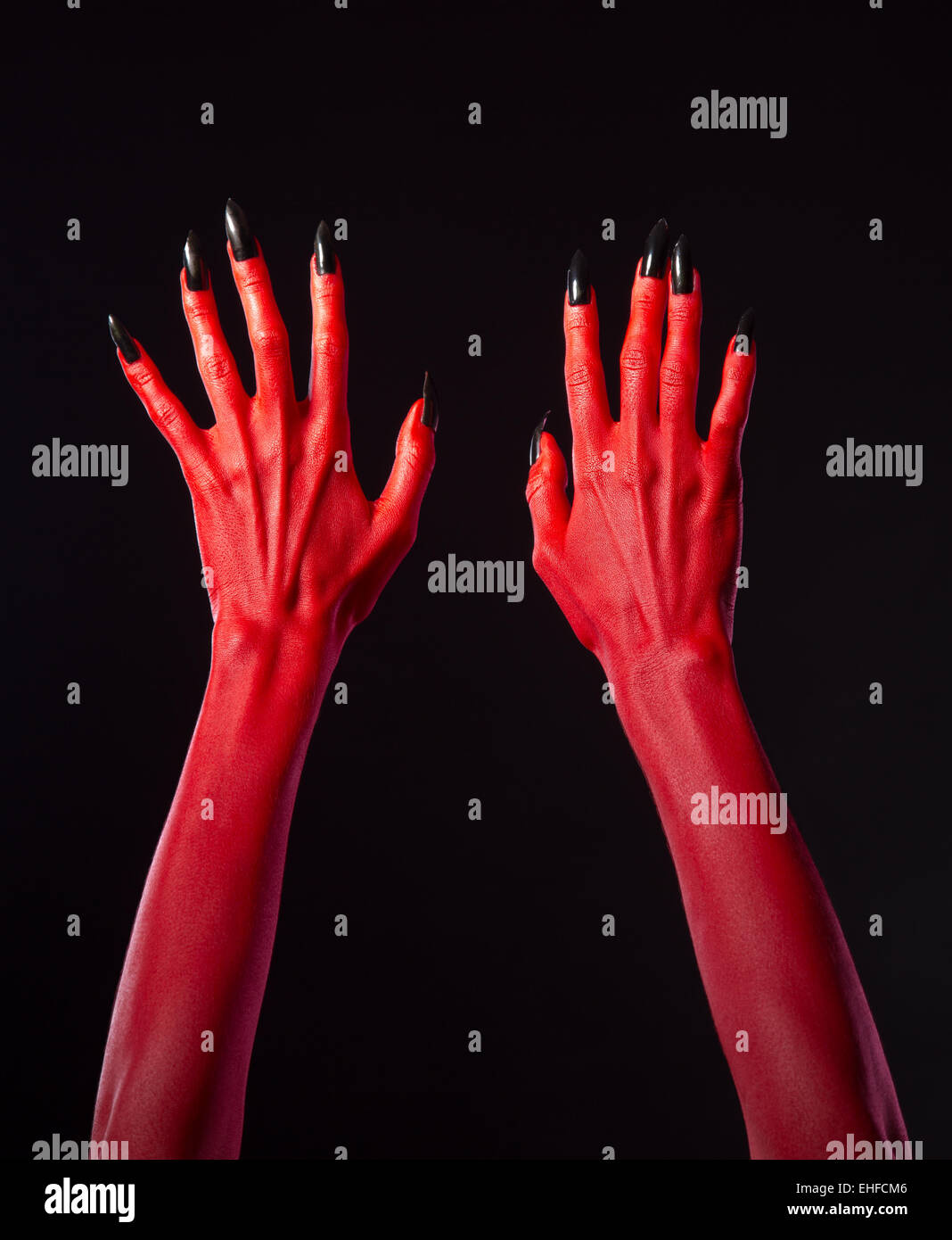 Red devil hands with black nails for Halloween theme, studio shot on ...
