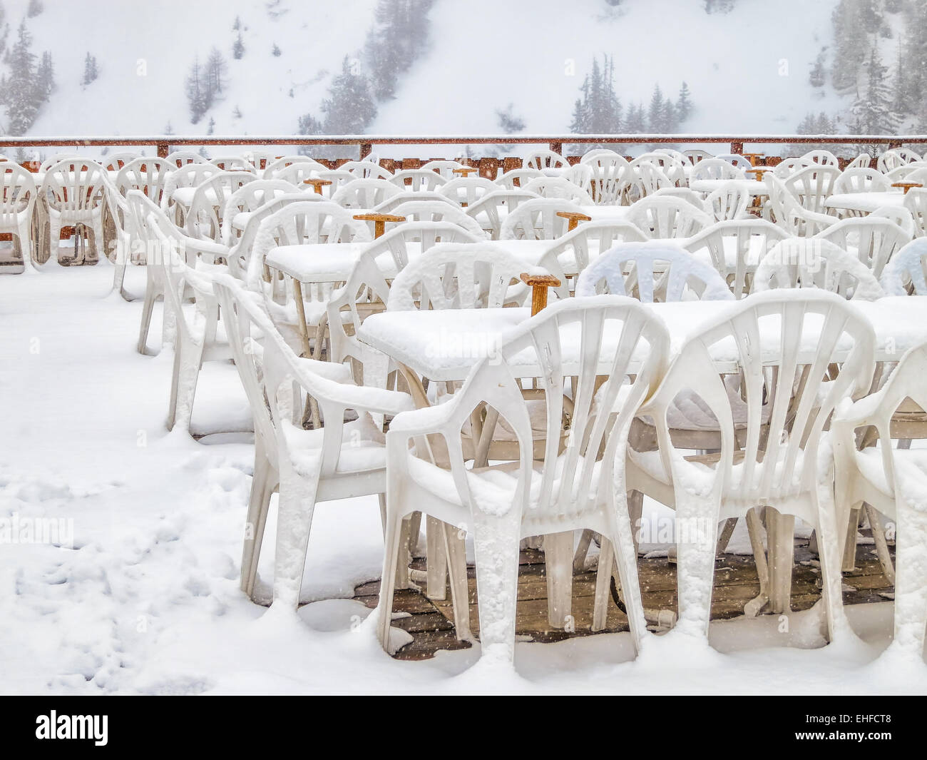 Rows of chairs in empty outdoor restaurant covered with snow, snowy ...