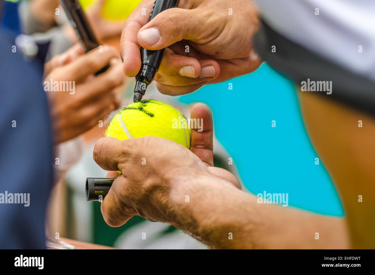 Tennis player signs autograph on a tennis ball after win, closeup photo ...