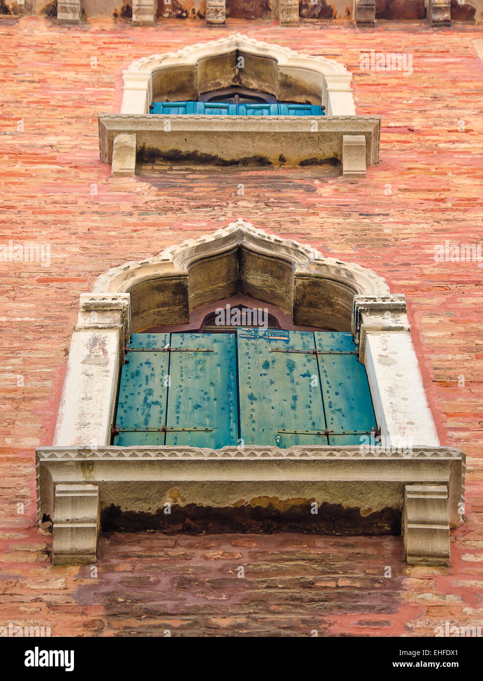 Old, medieval arched windows with blue and green shutters in Venice ...