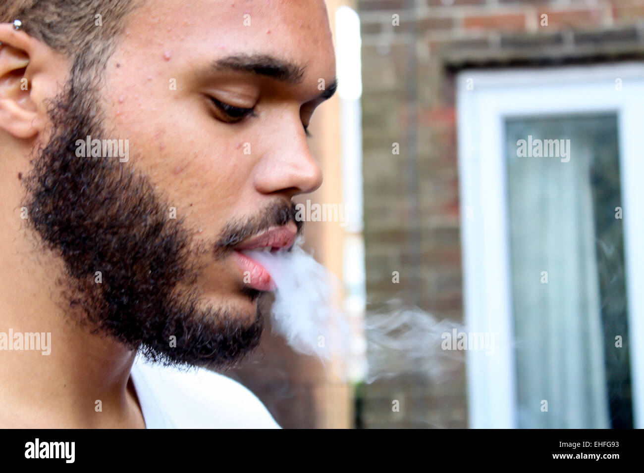 Young man smoking a joint model released Stock Photo - Alamy